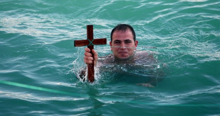 Orthodox Christians dive into ice-cold waters to chase wooden crosses